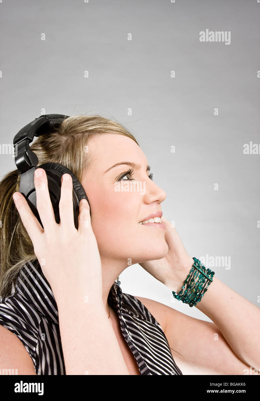 A pretty young woman listening to music on stereo headphones, shot in ...