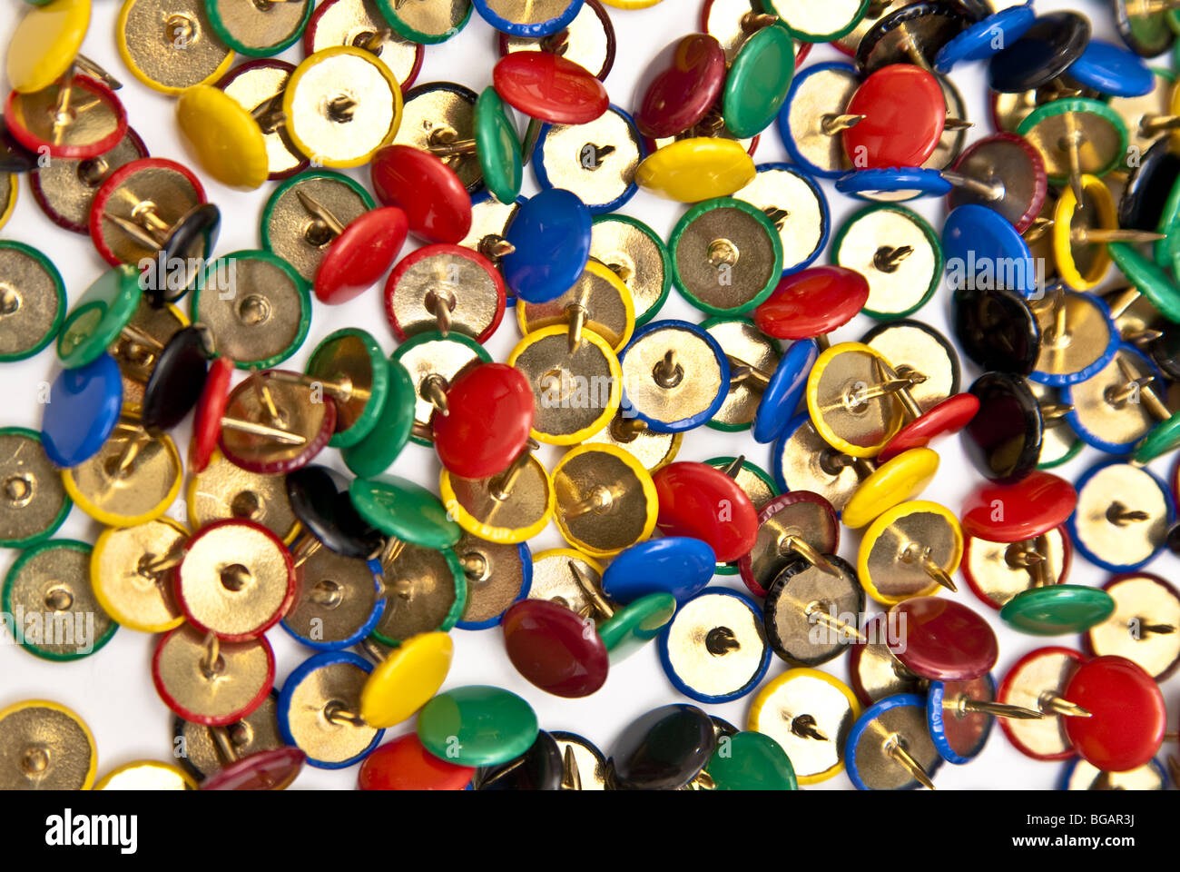colorful thumbtacks goes to pieces on white background Stock Photo - Alamy
