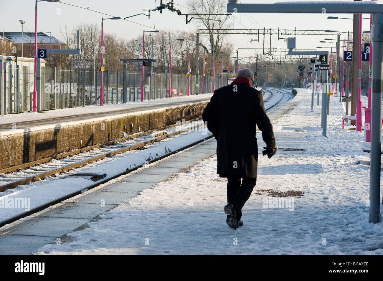 A commuter on a snow covered railway station platform in Essex Stock ...