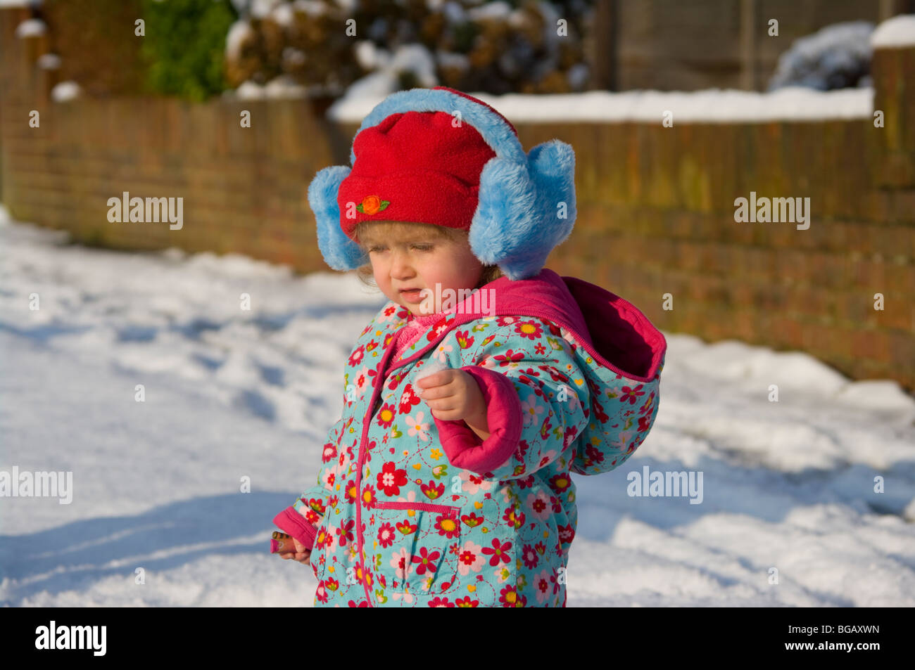 Baby Girl In The Snow Dressed In A Colourful Warm Coat Stock Photo - Alamy