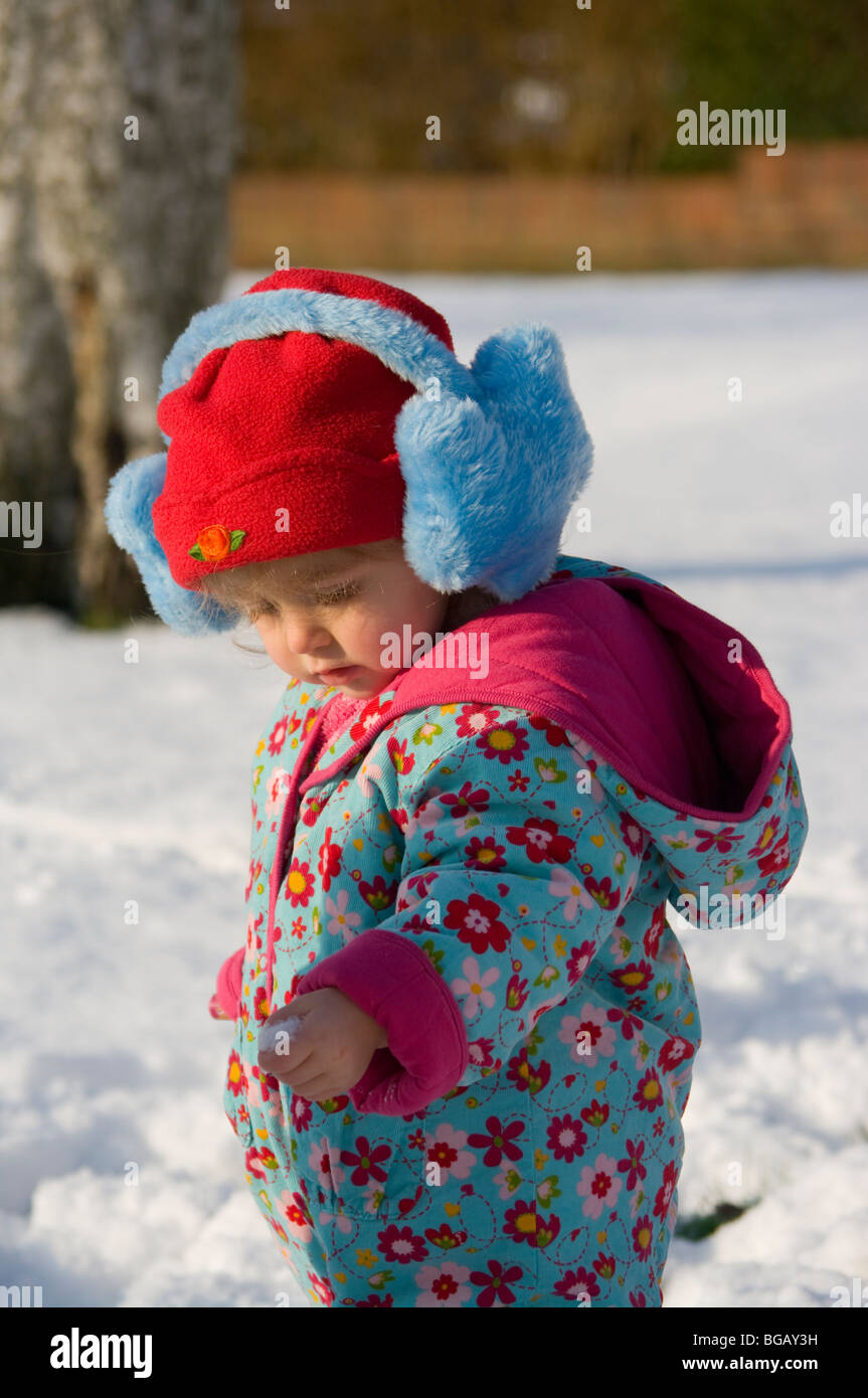 Baby Girl In The Snow Dressed In A Colourful Warm Coat Stock Photo - Alamy