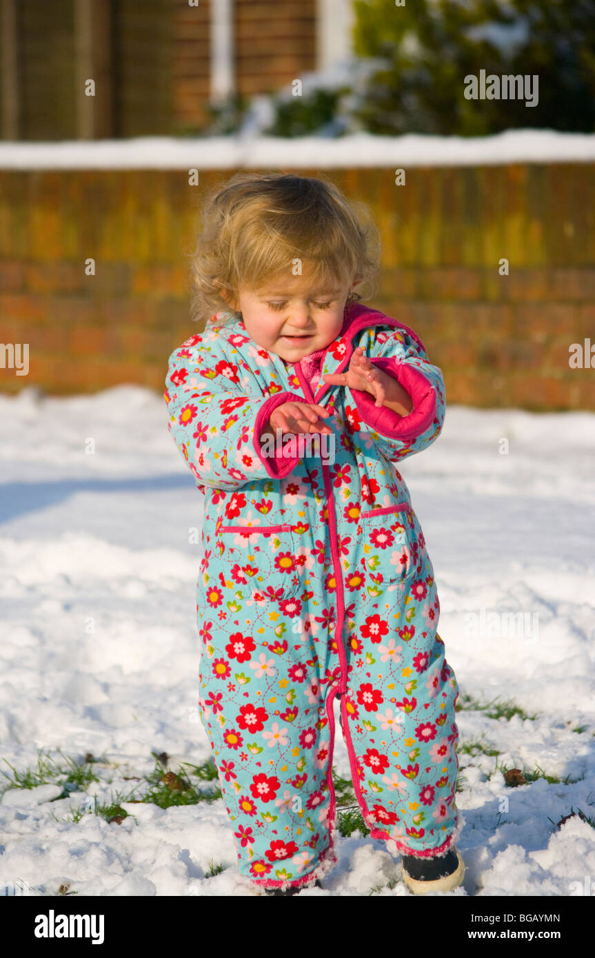 Baby Girl In The Snow Dressed In A Colourful Warm Coat Stock Photo - Alamy