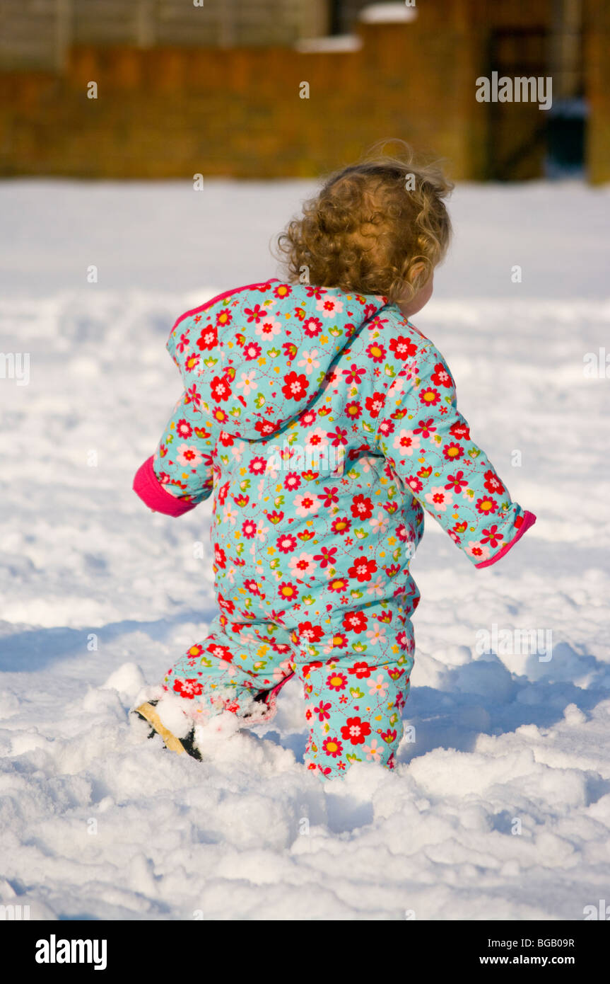 Baby Girl In The Snow Dressed In A Colourful Warm Coat Stock Photo - Alamy