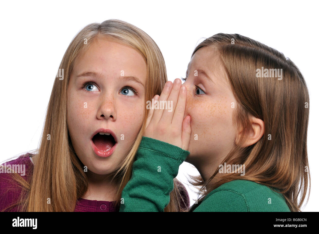 Two girls telling a secret and expressing surprise isolated on white ...