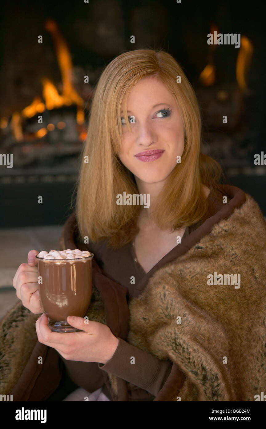 Girl drinking hot chocolate near fire Stock Photo - Alamy