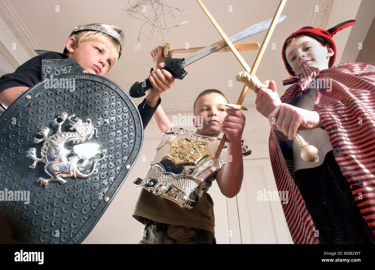 Three boys playing with toy swords Stock Photo - Alamy