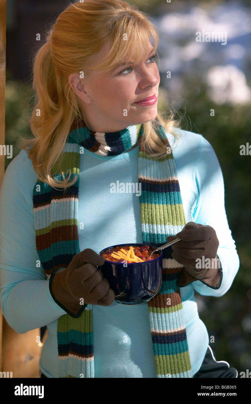 Woman eating chili outside on porch in snow Stock Photo - Alamy