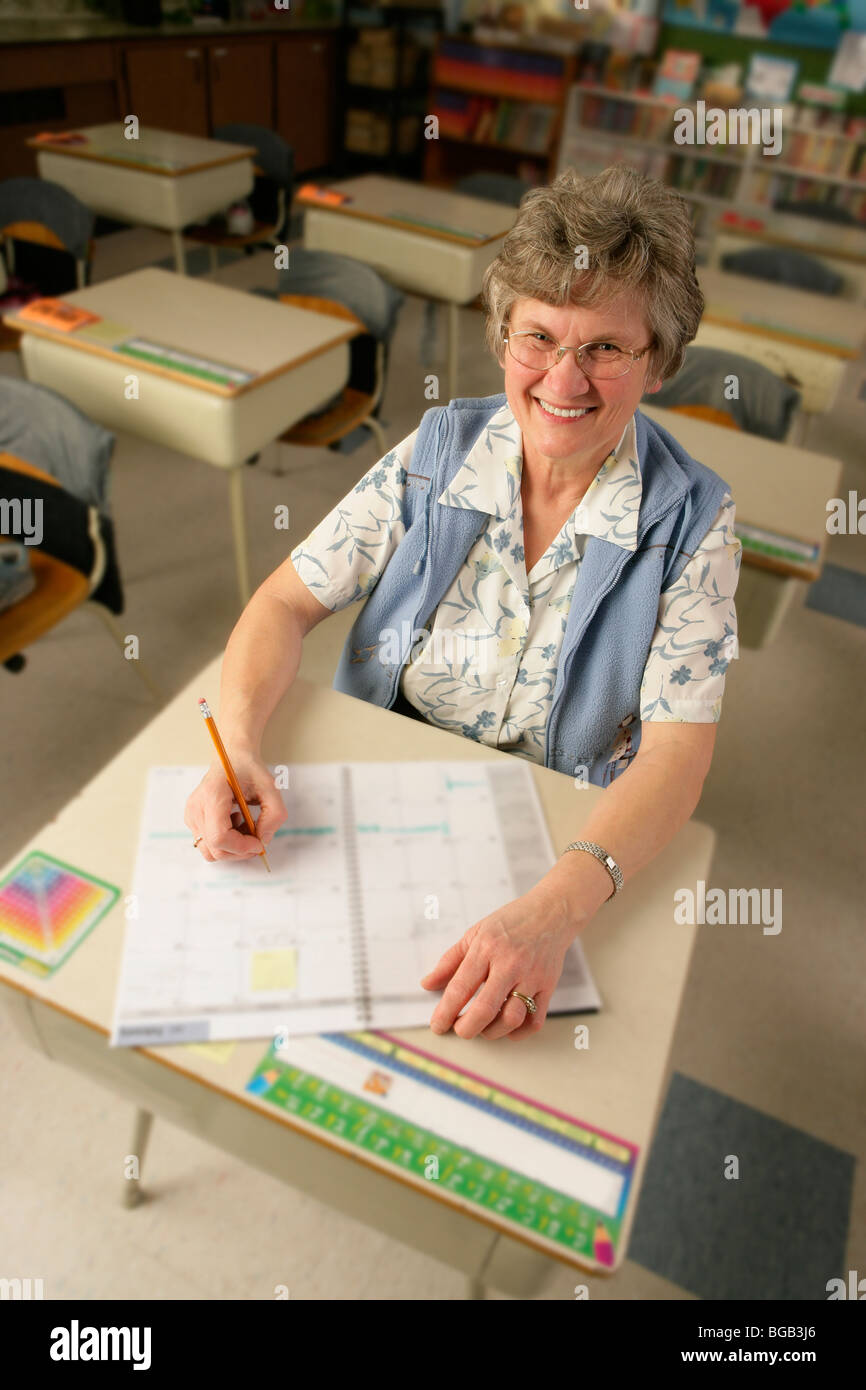 Teacher; Teacher Sitting At School Desk Stock Photo - Alamy