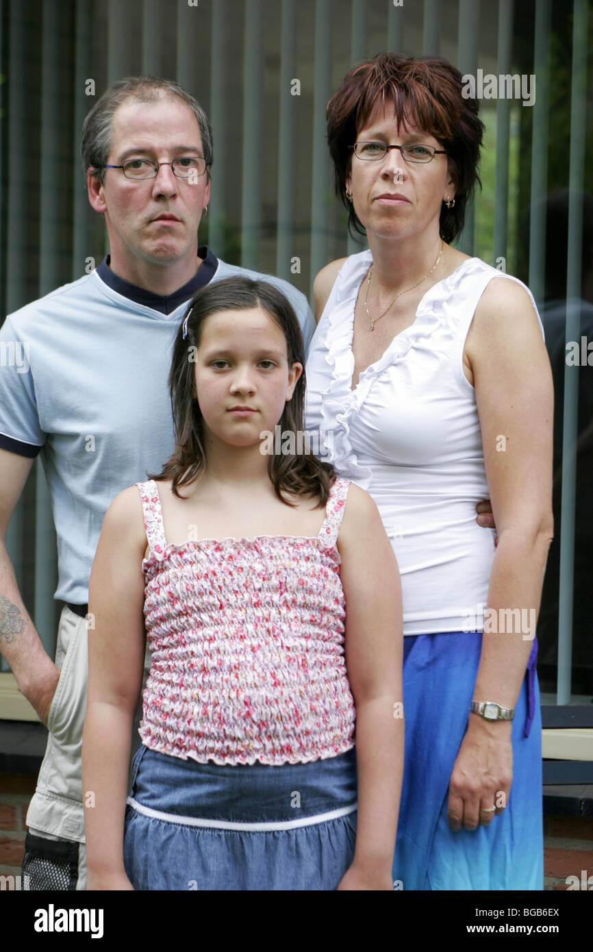 Family unit serious portrait standing in front of house ...
