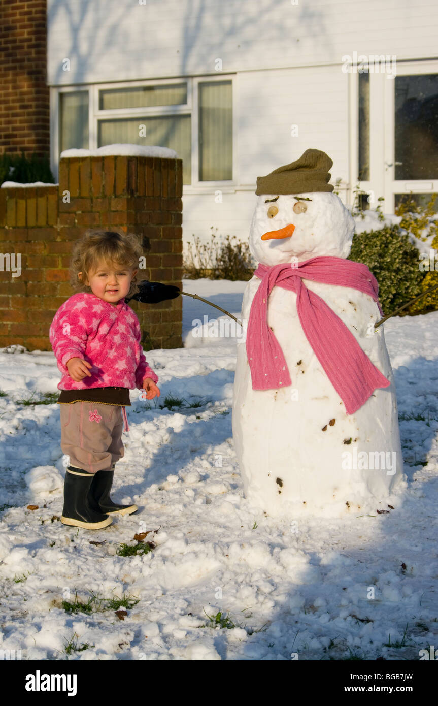 Baby Girl With A Snowman Stock Photo - Alamy