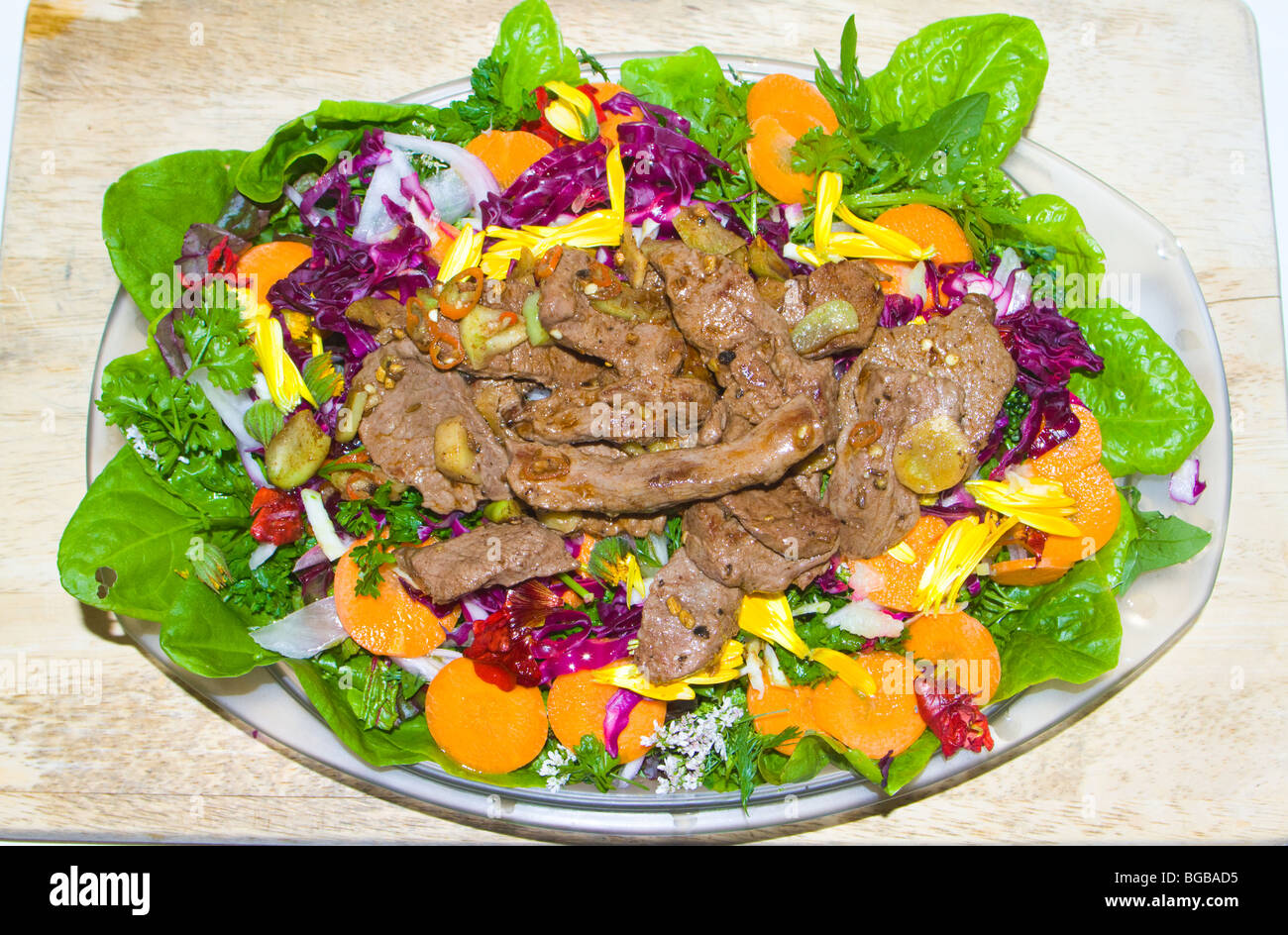 Venison and salad with edible flowers Stock Photo - Alamy
