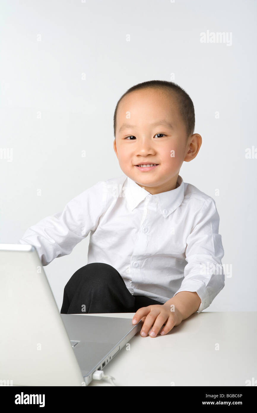 Young boy sitting with a laptop Stock Photo - Alamy