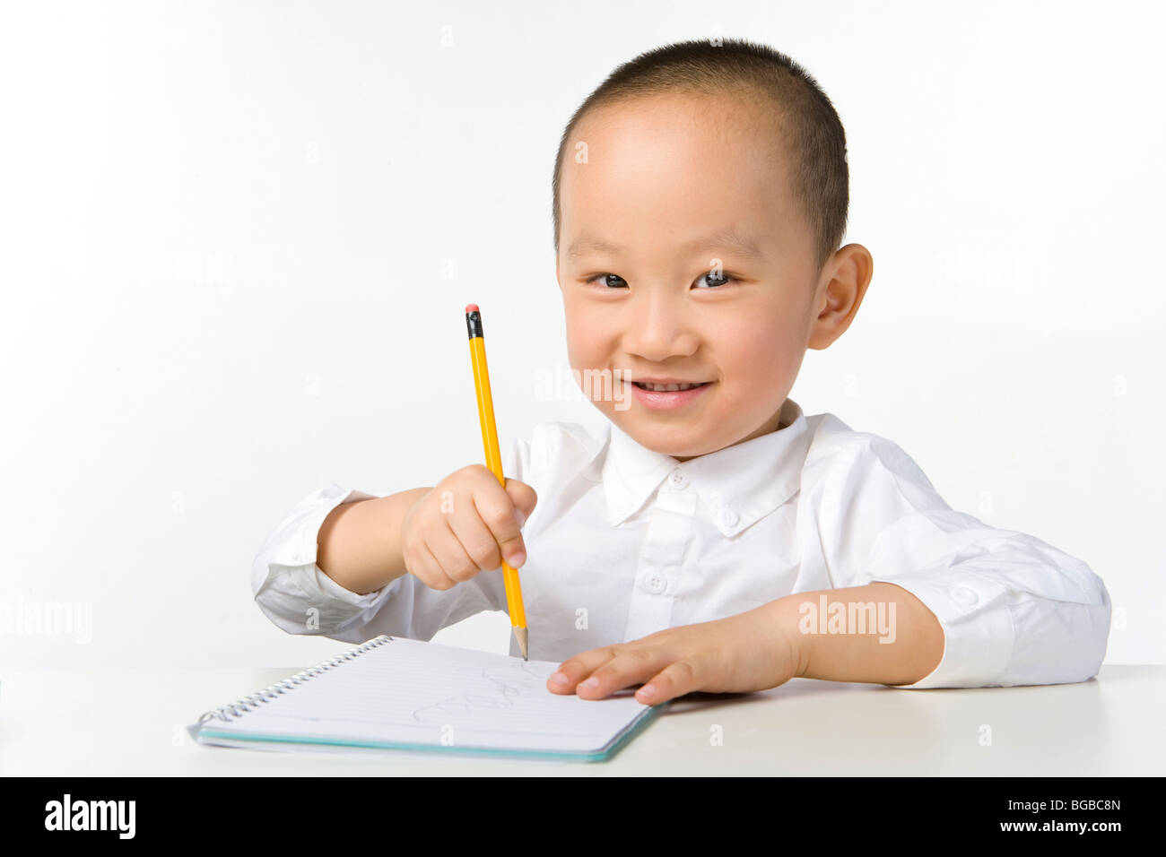 Young boy writes on a notebook Stock Photo - Alamy