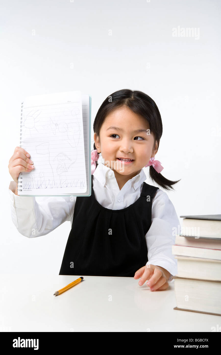Little girl holds up her notebook Stock Photo - Alamy