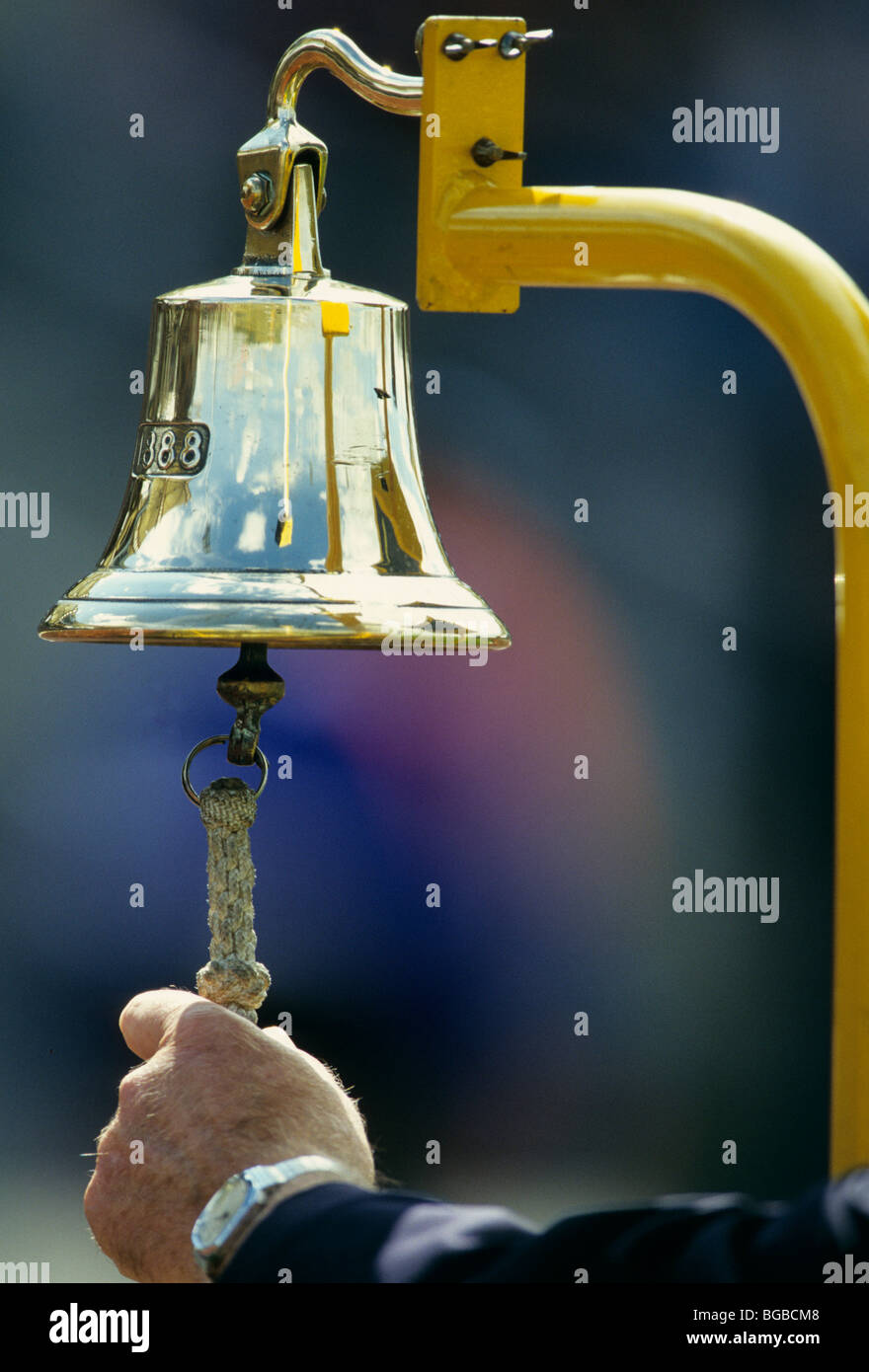 Official holding a starting bell Stock Photo - Alamy
