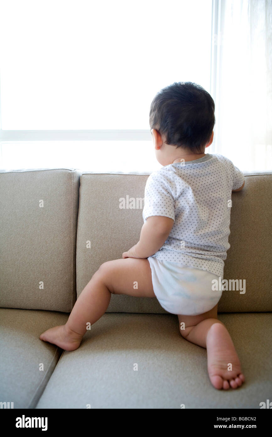 Infant looking out window Stock Photo - Alamy