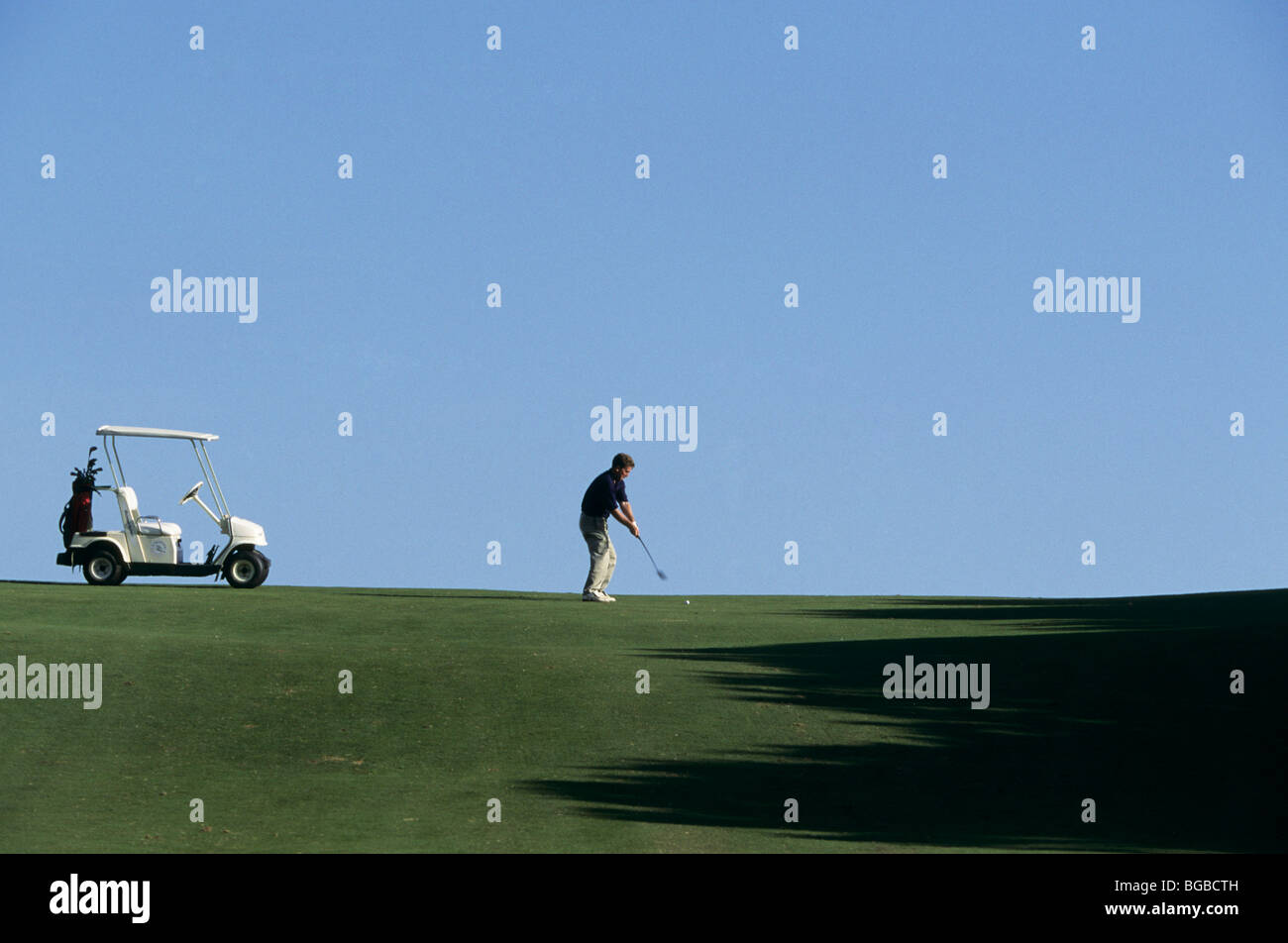 Golfer and a golf cart Stock Photo - Alamy
