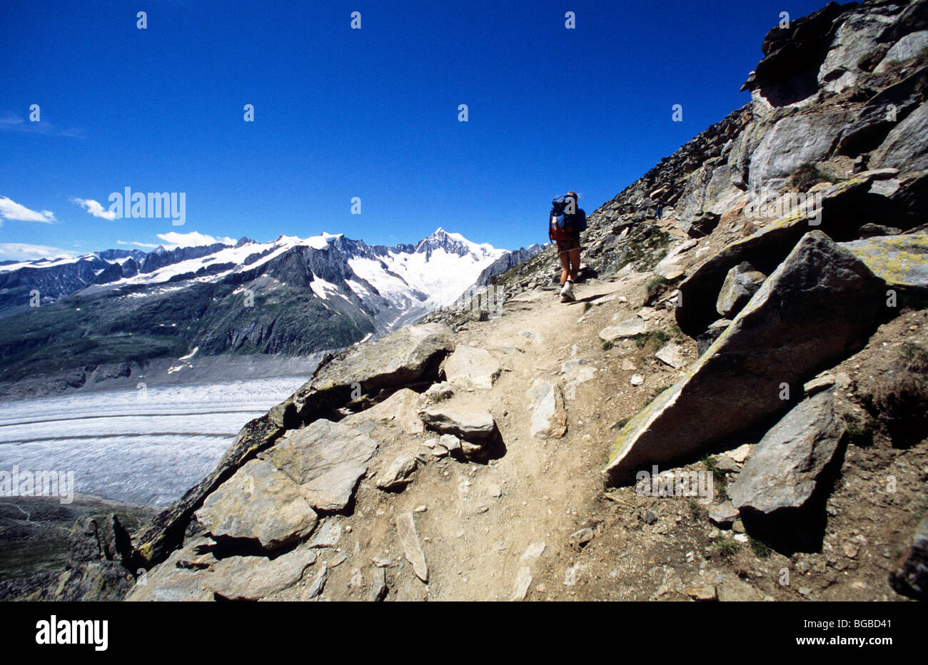 Hill walker walking along a the edge of a rocky mountain Stock Photo ...
