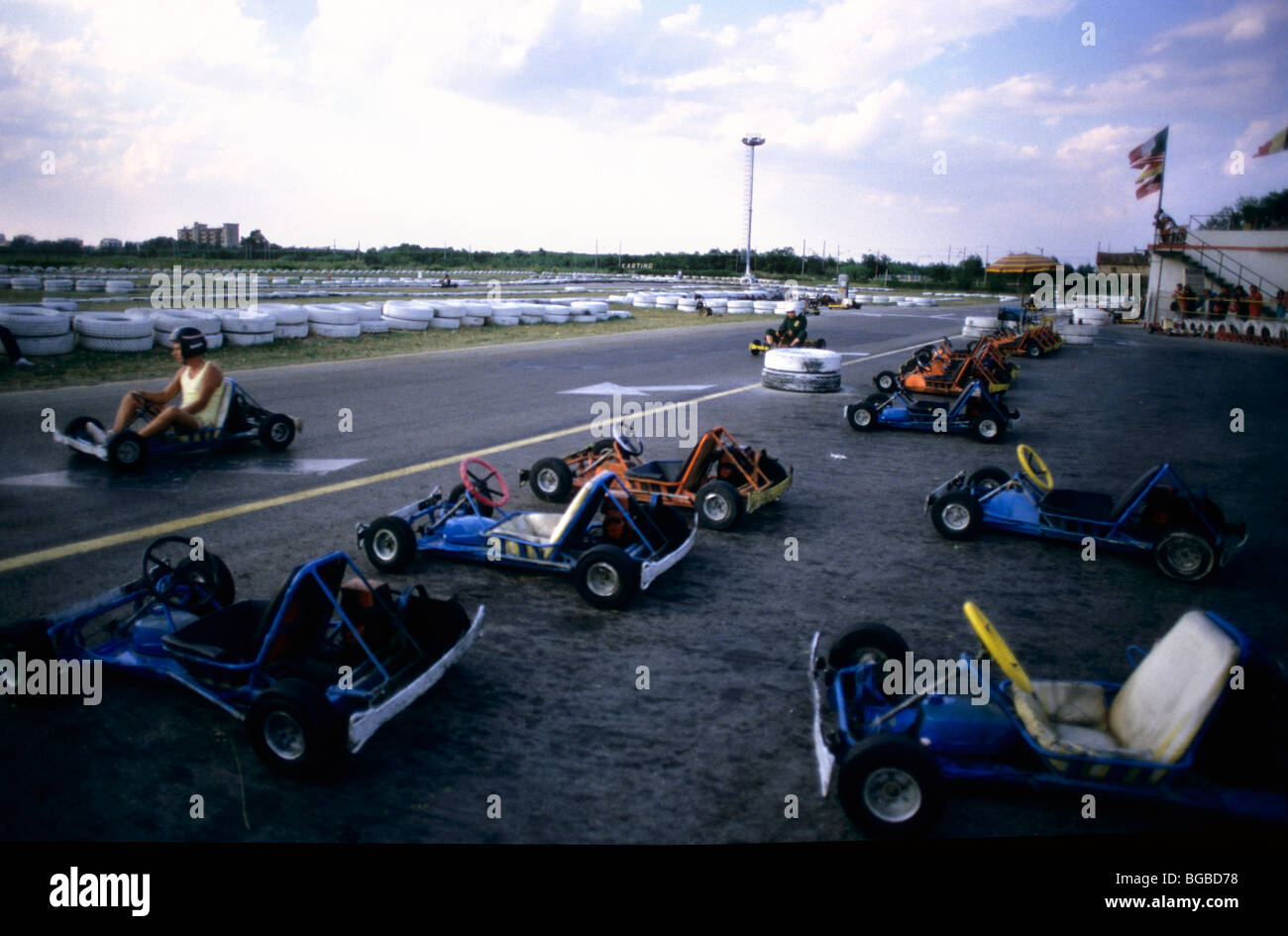 Two men driving go karts by several go karts in a pit stop Stock Photo ...