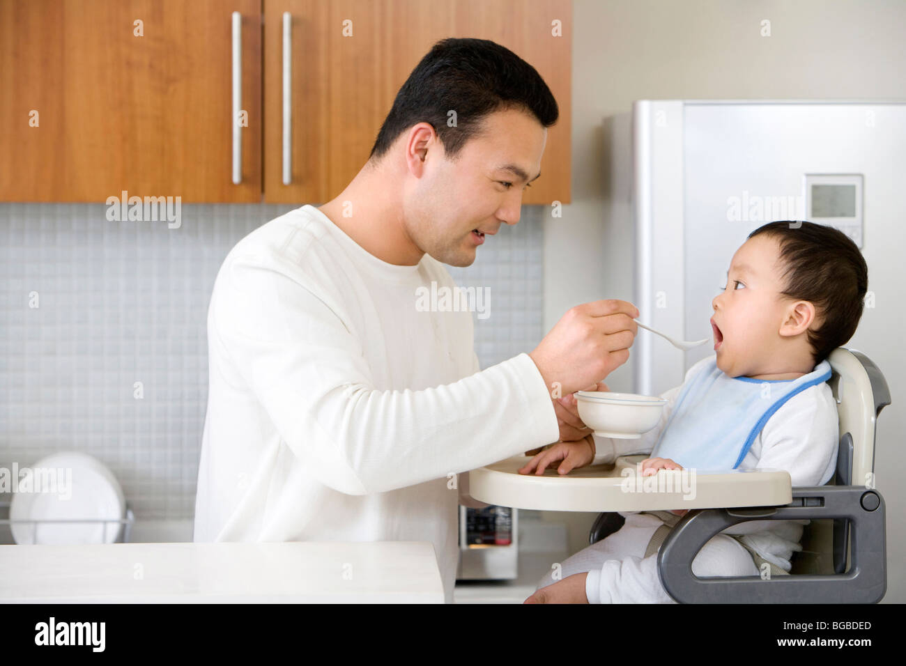 Man feeding infant Stock Photo - Alamy