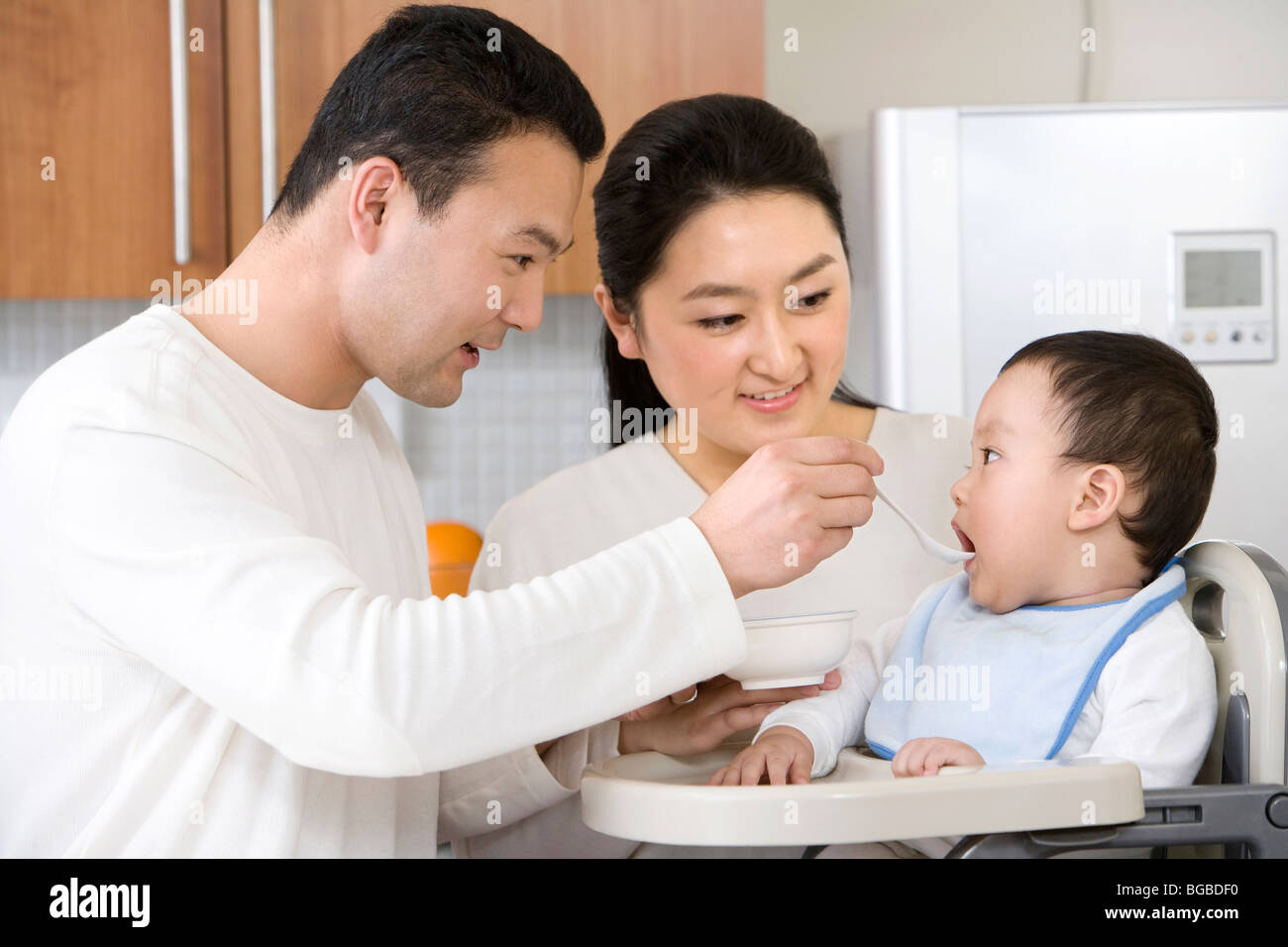 Family feeding child Stock Photo - Alamy