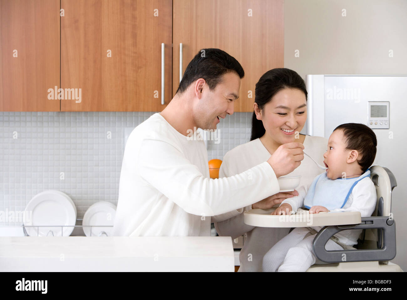 Family feeding child Stock Photo - Alamy
