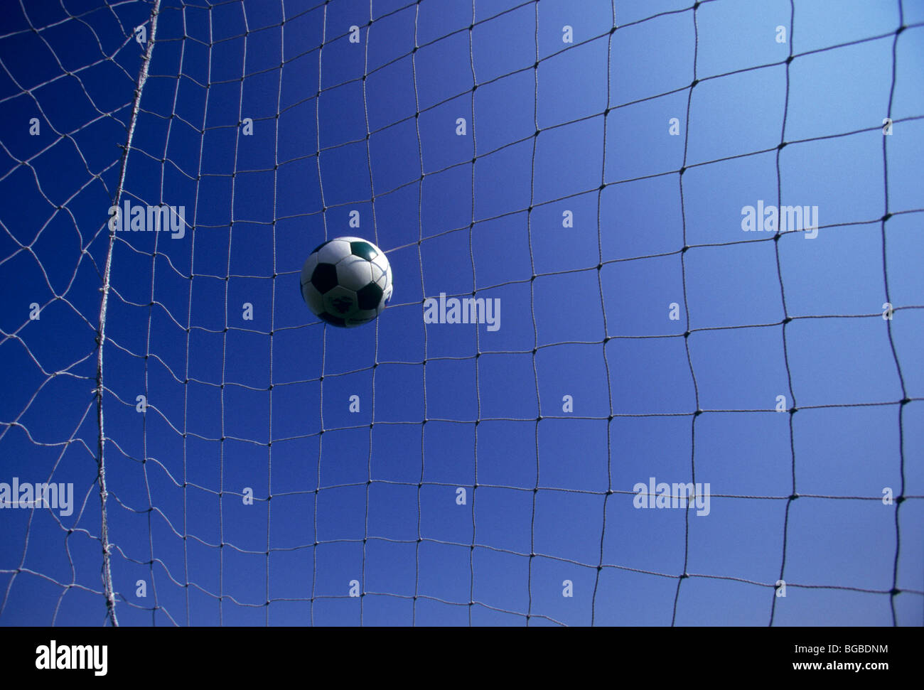 Football in a goal net against blue sky Stock Photo - Alamy