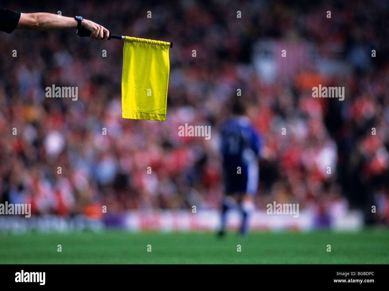 Referee holding up a yellow flag Stock Photo - Alamy