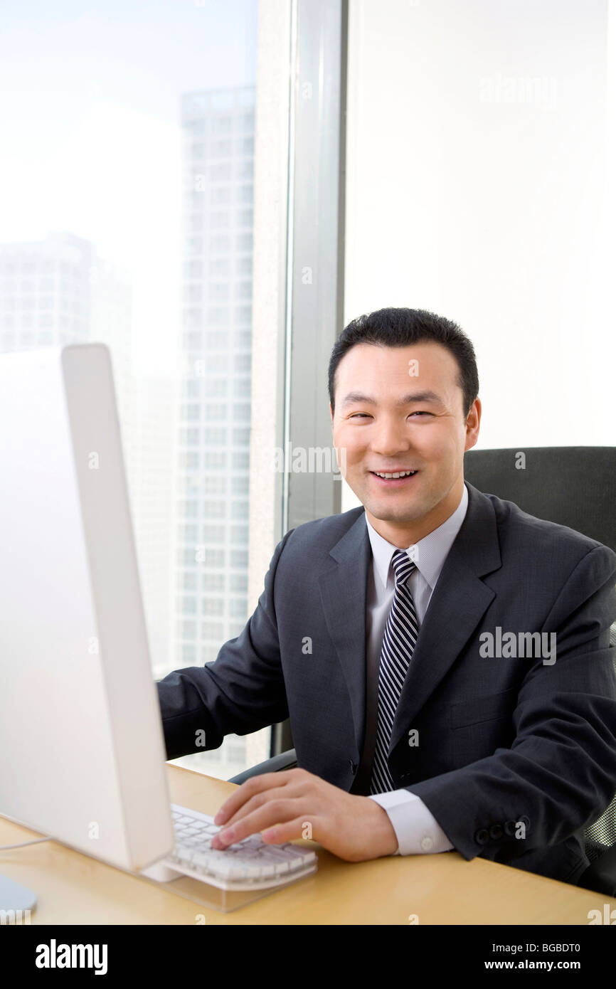 Man uses computer in a well-lit, sunny office Stock Photo - Alamy