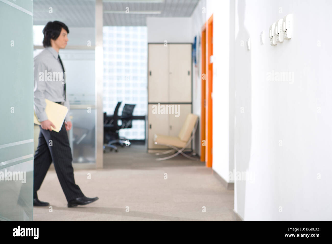 Young businessman walks through office Stock Photo - Alamy