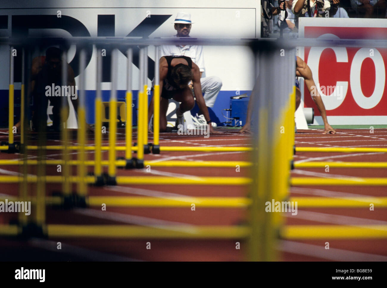 View through hurdles of athletes preparing for 100m race Stock Photo ...