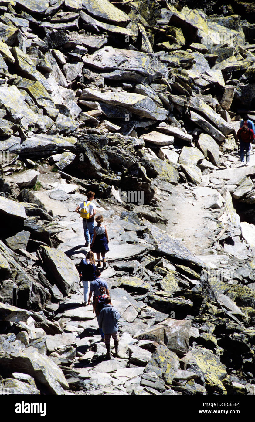 Group of walkers walking along a very rocky hill path Stock Photo - Alamy