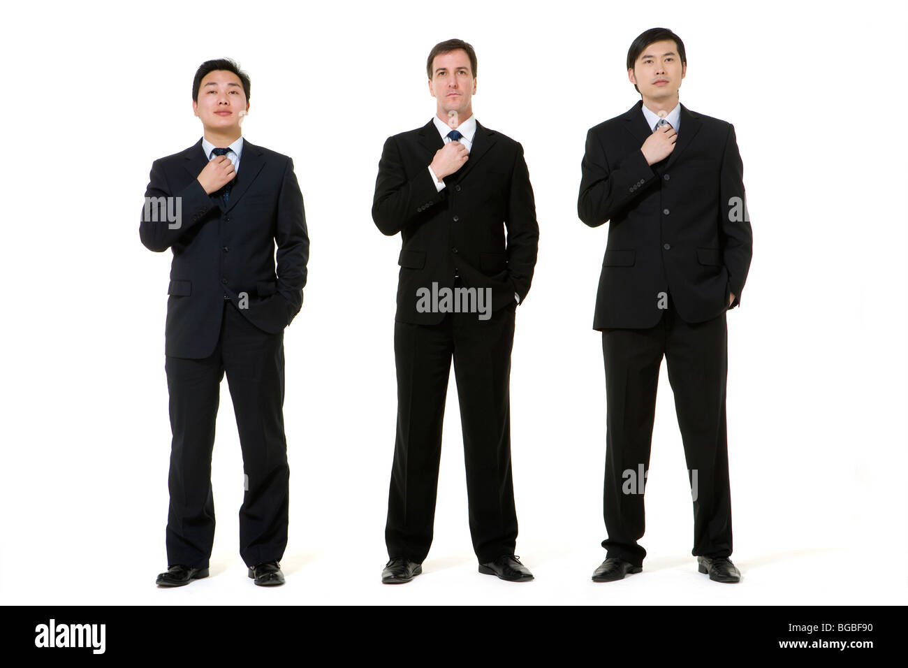 Three business professionals dressing in dark suits on light background ...