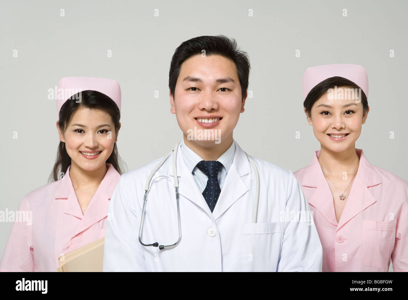 Doctor with nurses in pink uniforms Stock Photo - Alamy