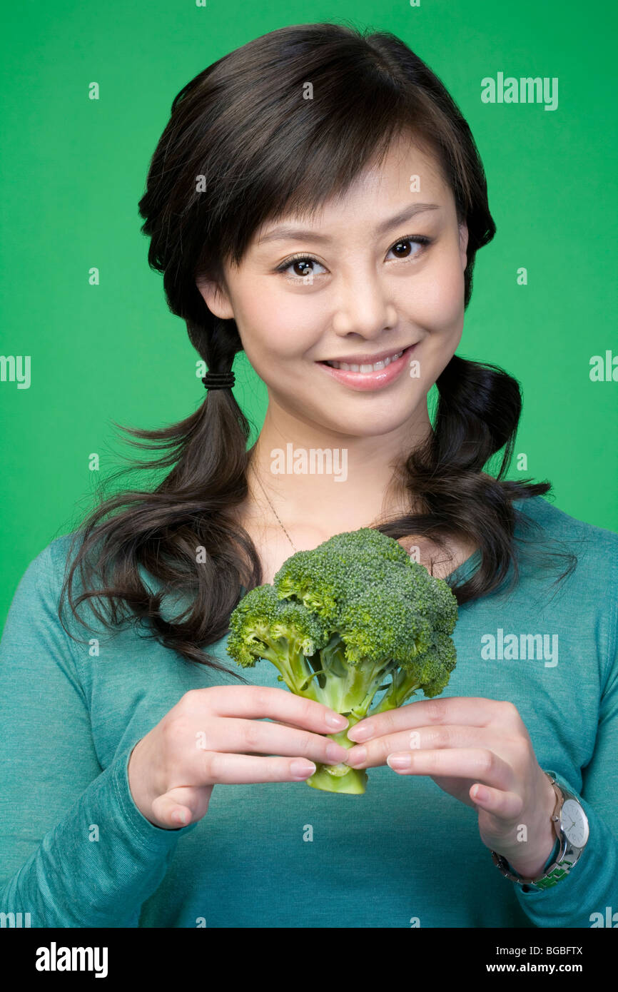 Woman on green background with broccoli Stock Photo - Alamy