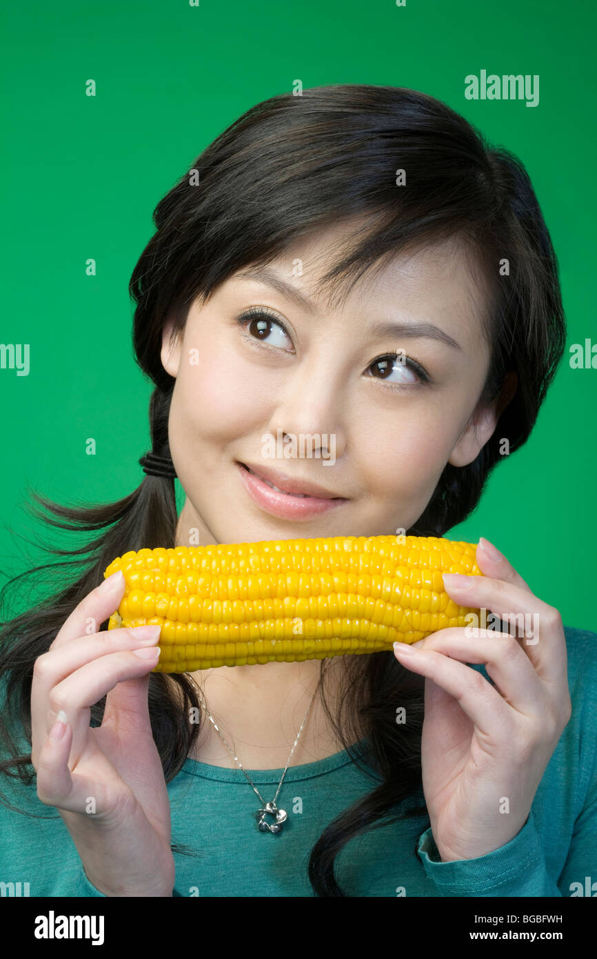 Woman on green background with corn Stock Photo - Alamy