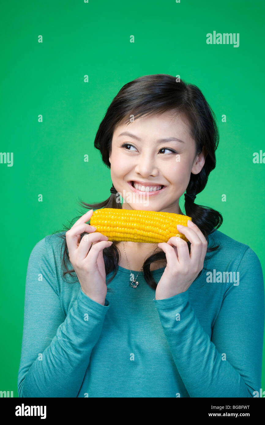 Woman on green background with corn Stock Photo - Alamy