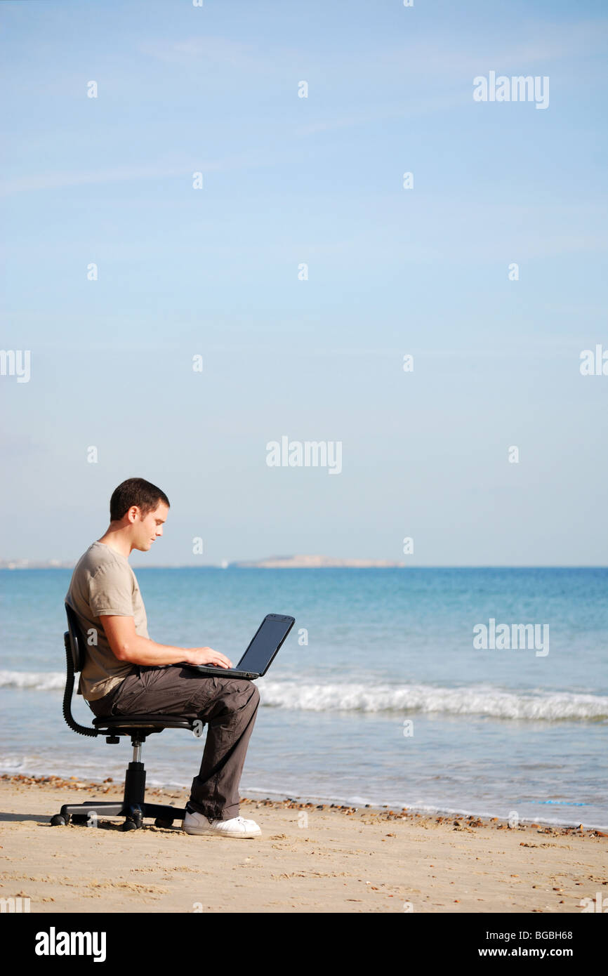 Man using laptop at the beach Stock Photo - Alamy