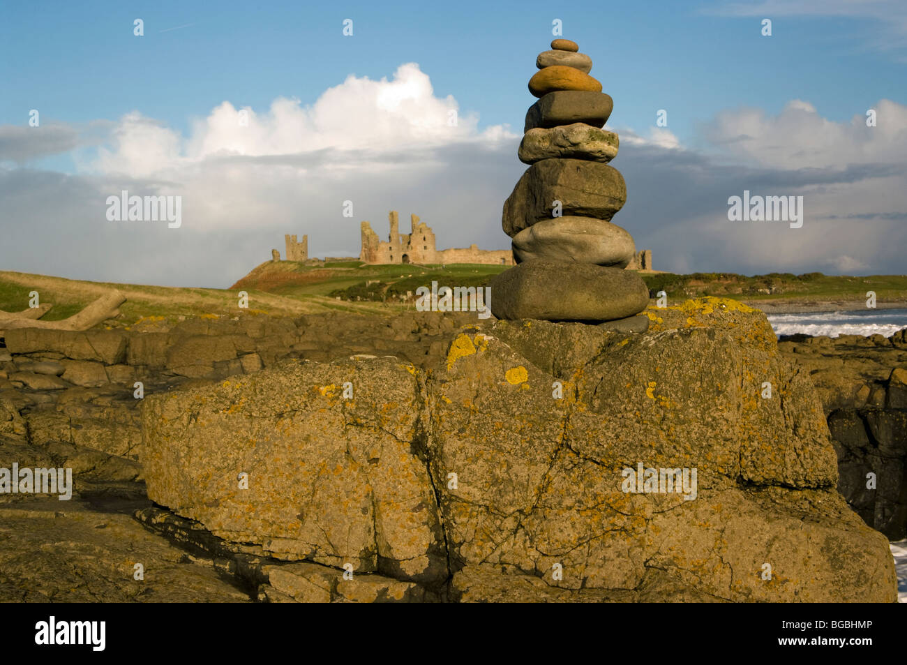A calming rock pile with Dunstanburgh castle visible in the distance ...