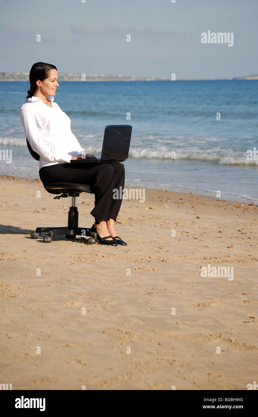 Young woman working on the beach Stock Photo - Alamy