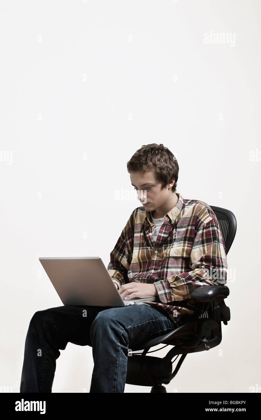 Teenage boy working on a laptop Stock Photo - Alamy