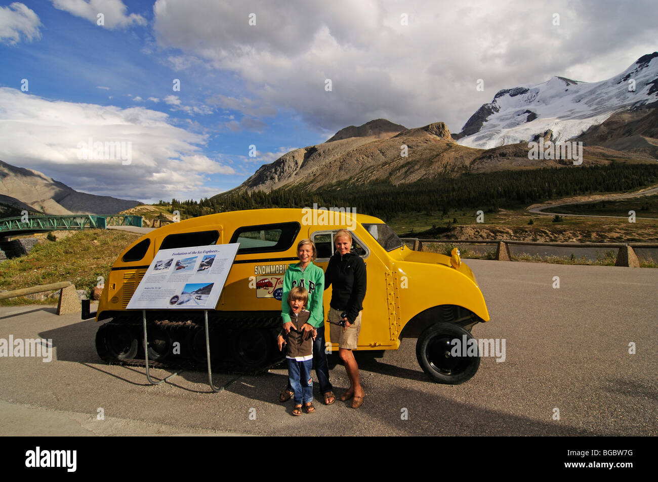 Women and children in front of an old snowmobile, Icefields Parkway ...
