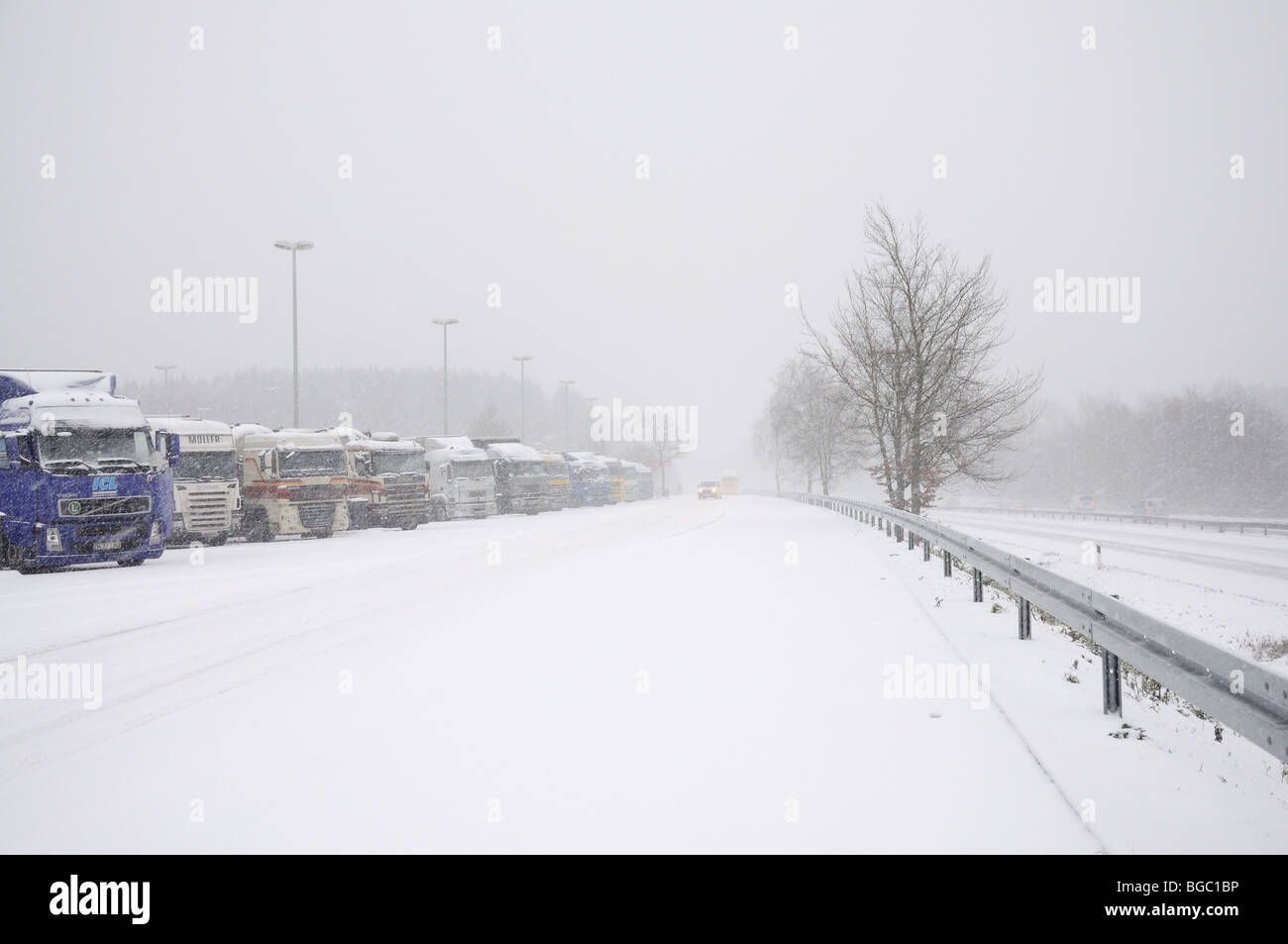 Trucks on a parking place on a German Autobahn in winter Stock Photo ...