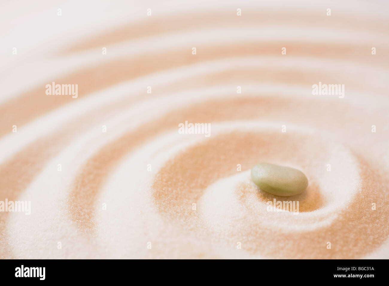 Single pebble in sand Stock Photo - Alamy