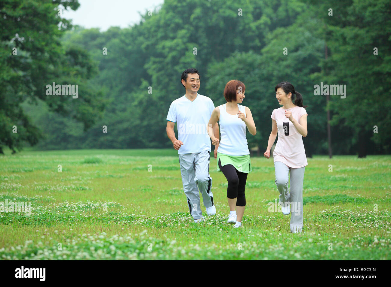 Three people walking Stock Photo - Alamy