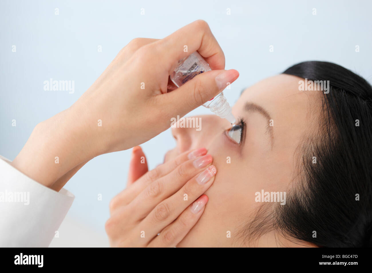 Mid adult woman putting eye-drops Stock Photo - Alamy