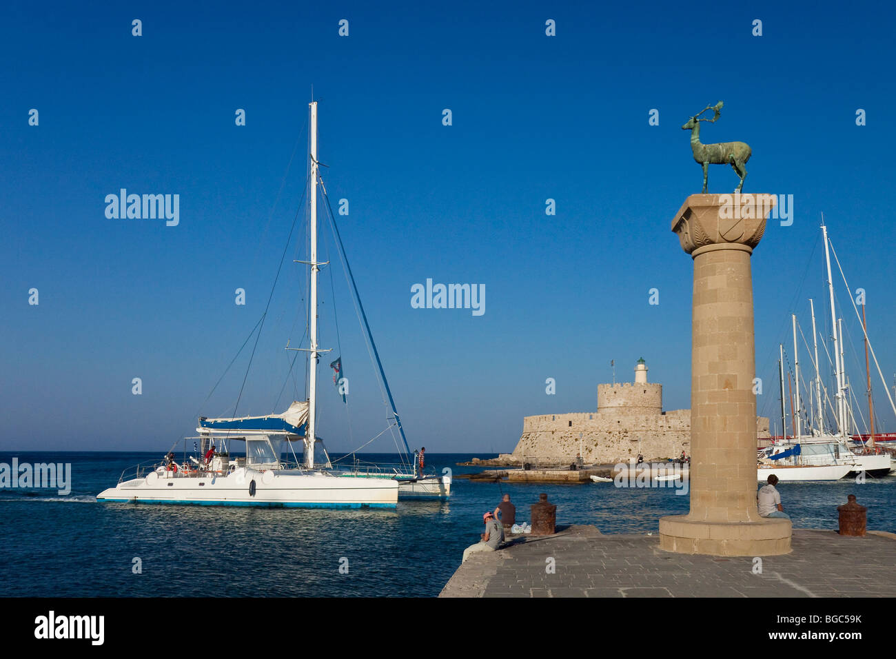Landmark stag, a catamaran passes the harbor entrance, Rhodes town ...