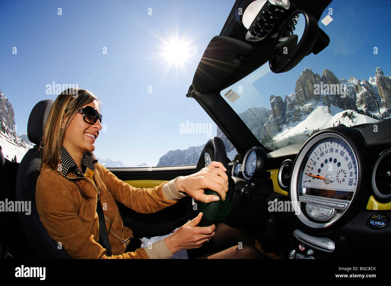 Woman driving Mini Cooper at the Gardena Pass, Alpine pass, South Tyrol ...