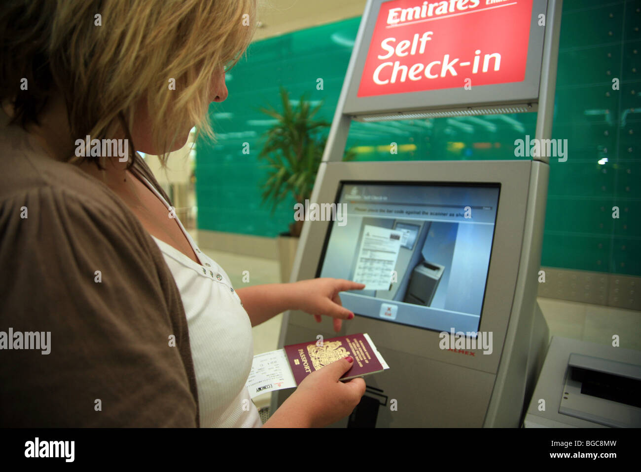 Self-check in and using a passport scanner at Dubai Airport Stock Photo ...