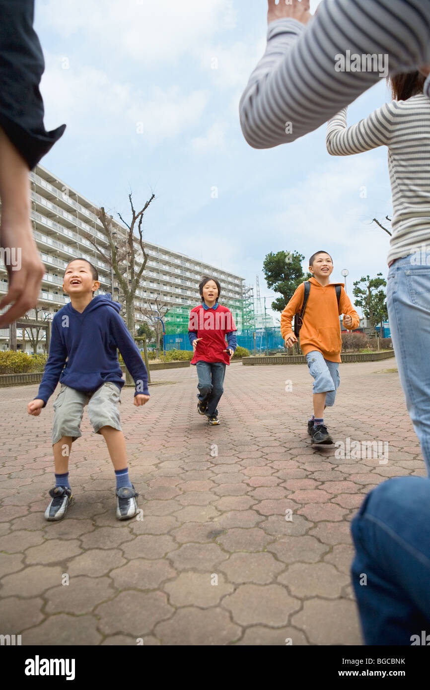 Three boys running to mothers Stock Photo - Alamy